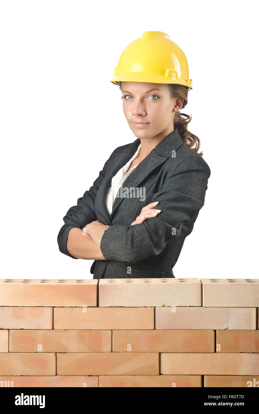 Young female builder near brick wall Stock Photo - Alamy