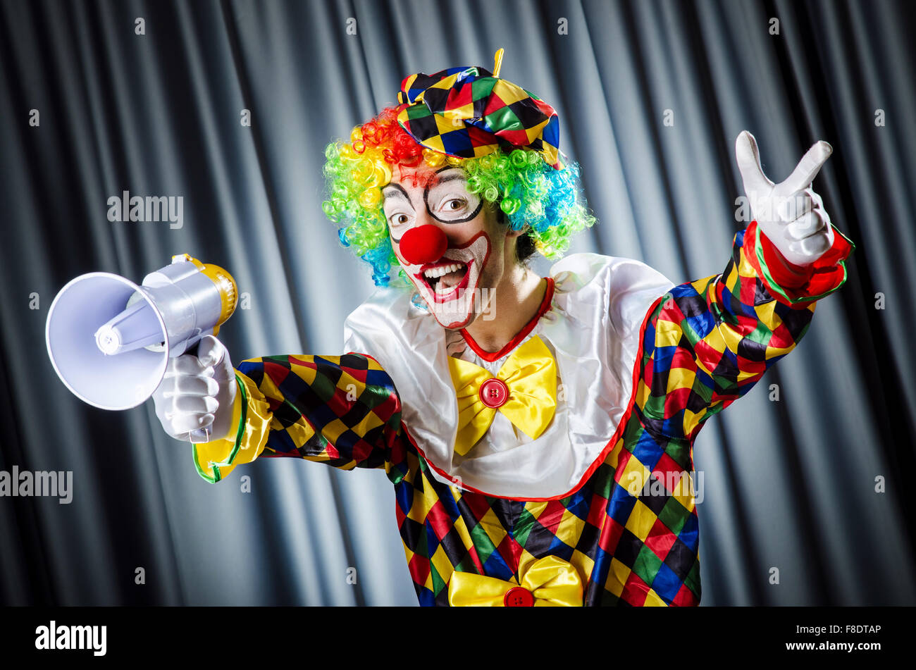 Clown in studio with loudspeaker Stock Photo - Alamy
