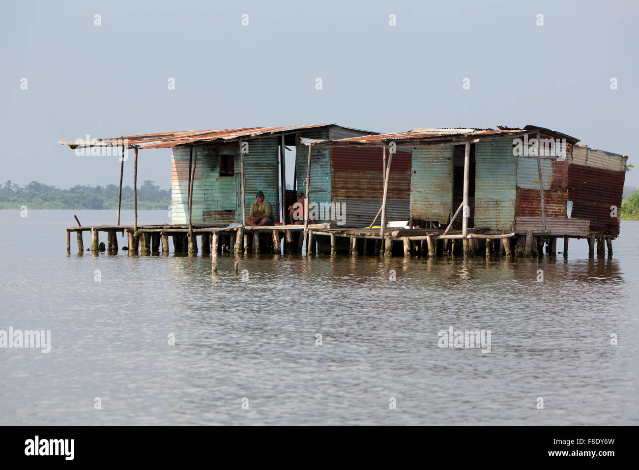 Fisher men sitting in poor wooden houses lifted up on Maracaibo Lake ...