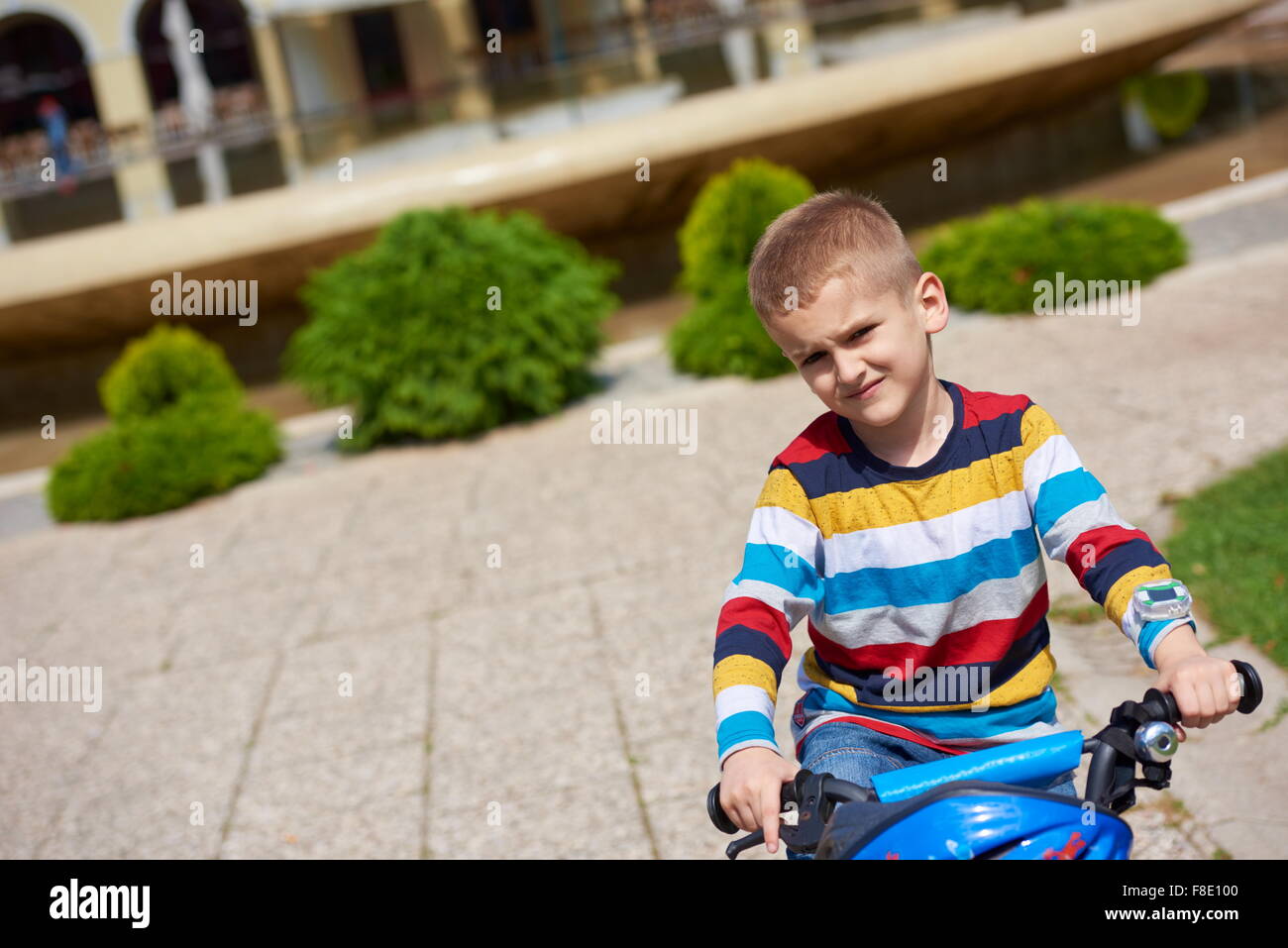 happy little boy have fun in park and learning to ride his first bike ...