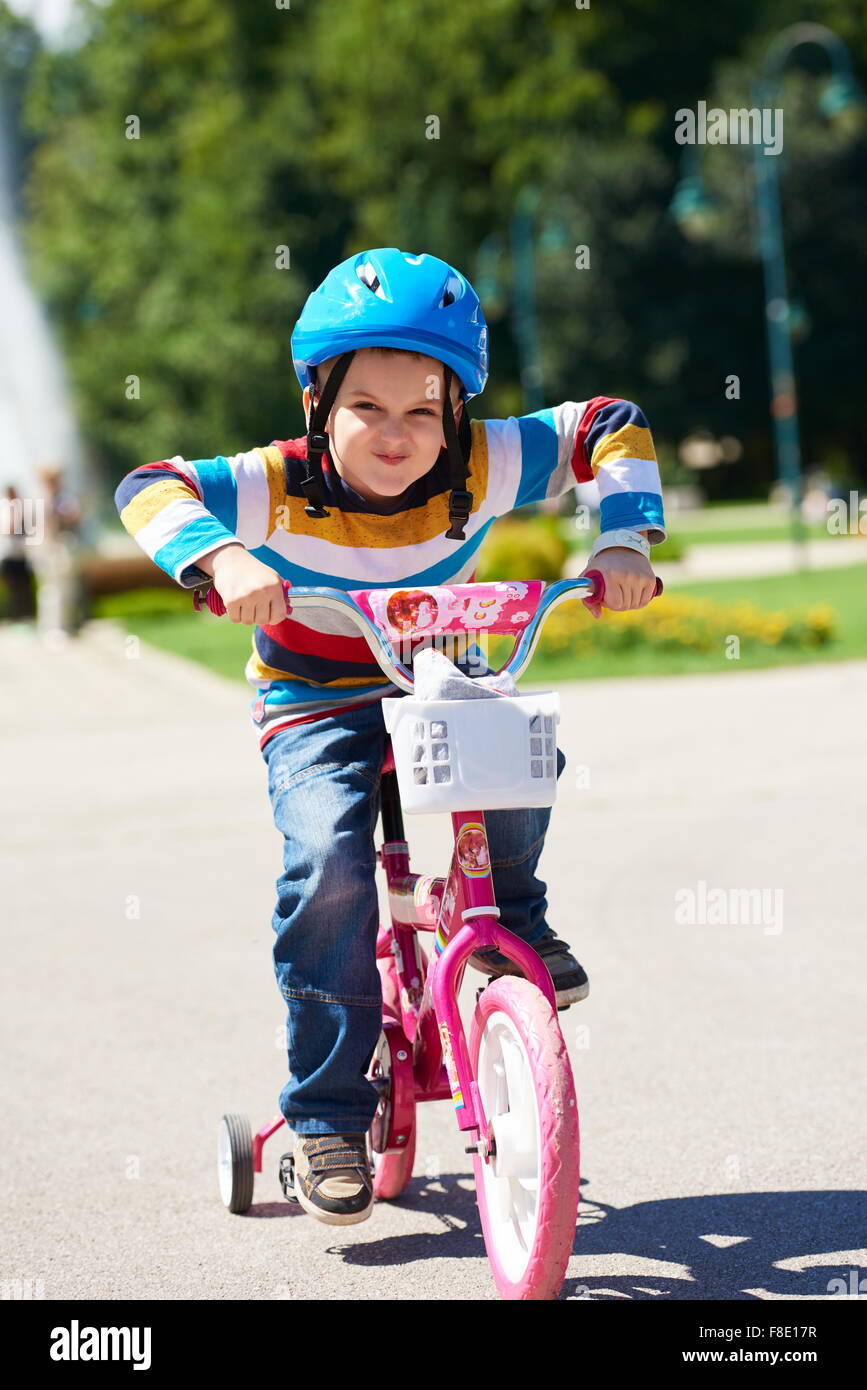 happy little boy have fun in park and learning to ride his first bike ...