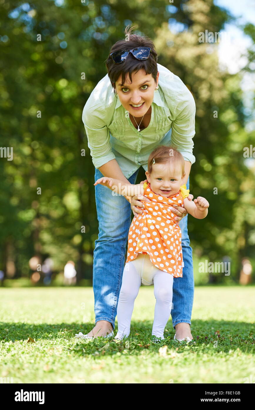 happy mother and baby child in park making first steps . Walking and ...