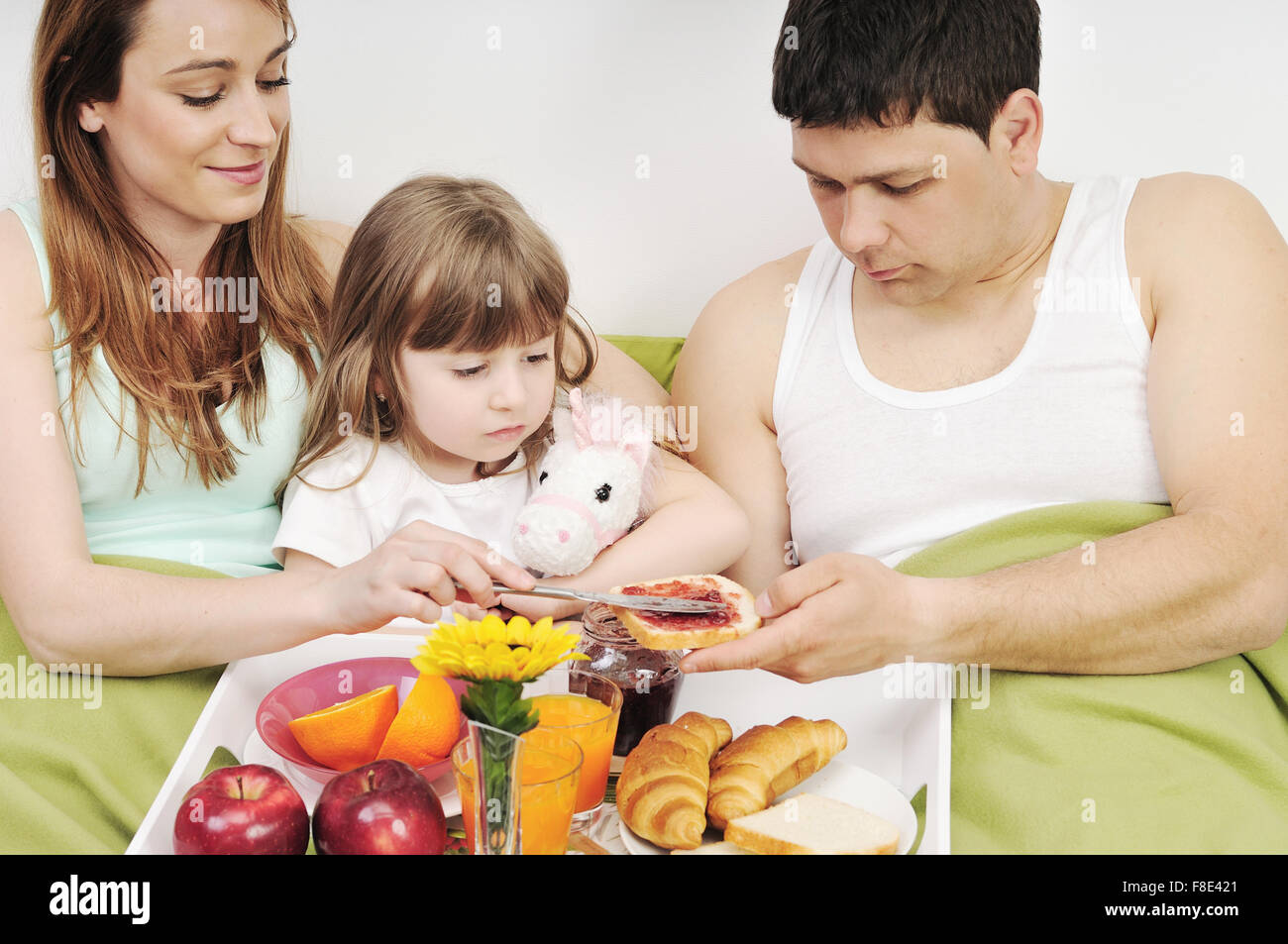 happy young family eat breakfast in bed at morning Stock Photo - Alamy