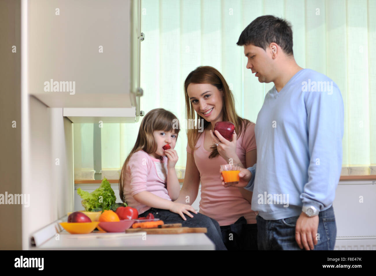 happy young family have lunch time with fresh fruits and vegetable food ...