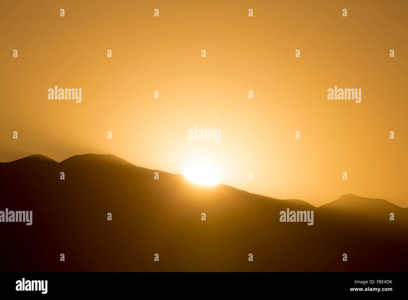 Dramatic sunset rays behind silhouette of mountain Stock Photo - Alamy
