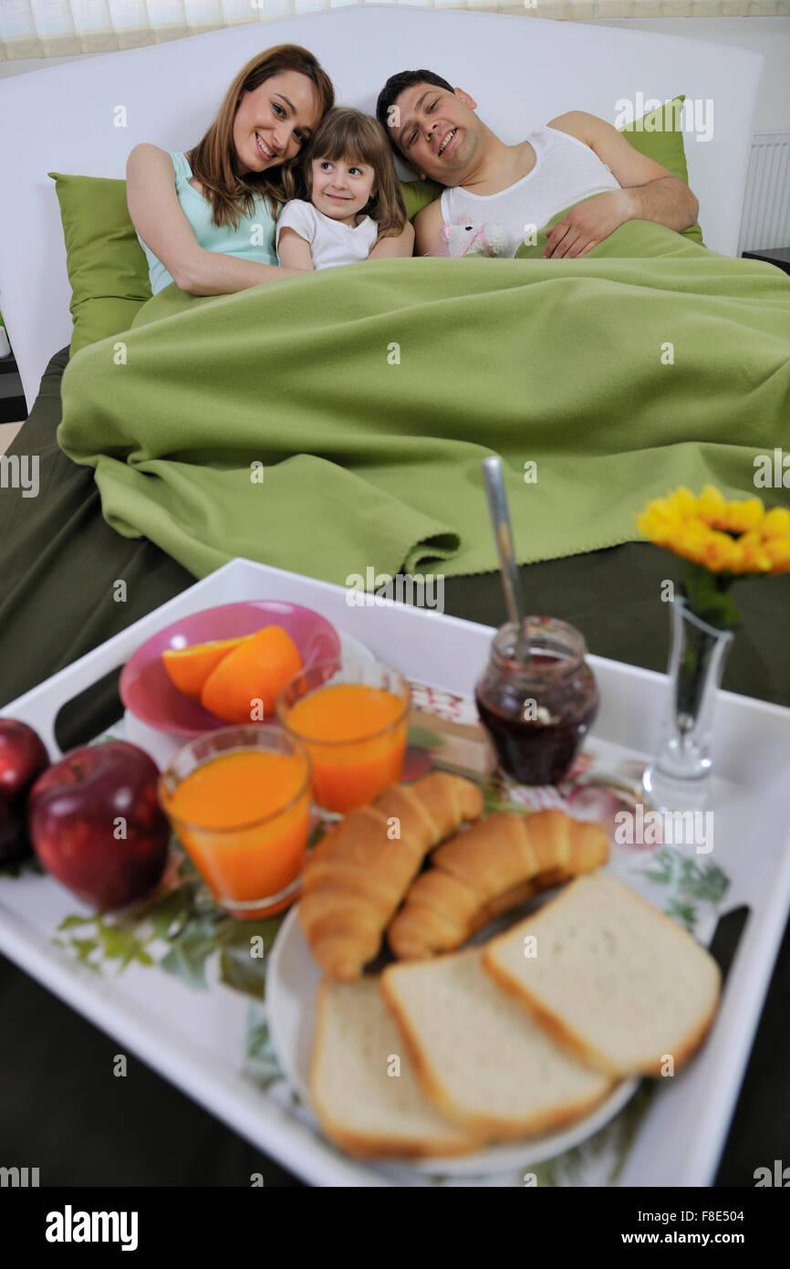 happy young family eat breakfast in bed at morning Stock Photo - Alamy