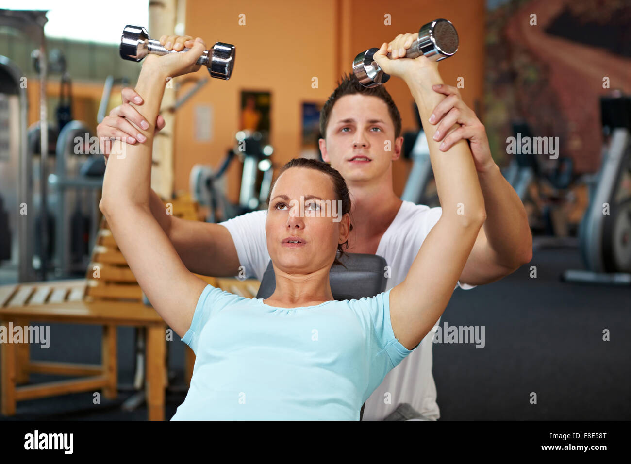 Woman doing weight training with fitness coach Stock Photo - Alamy