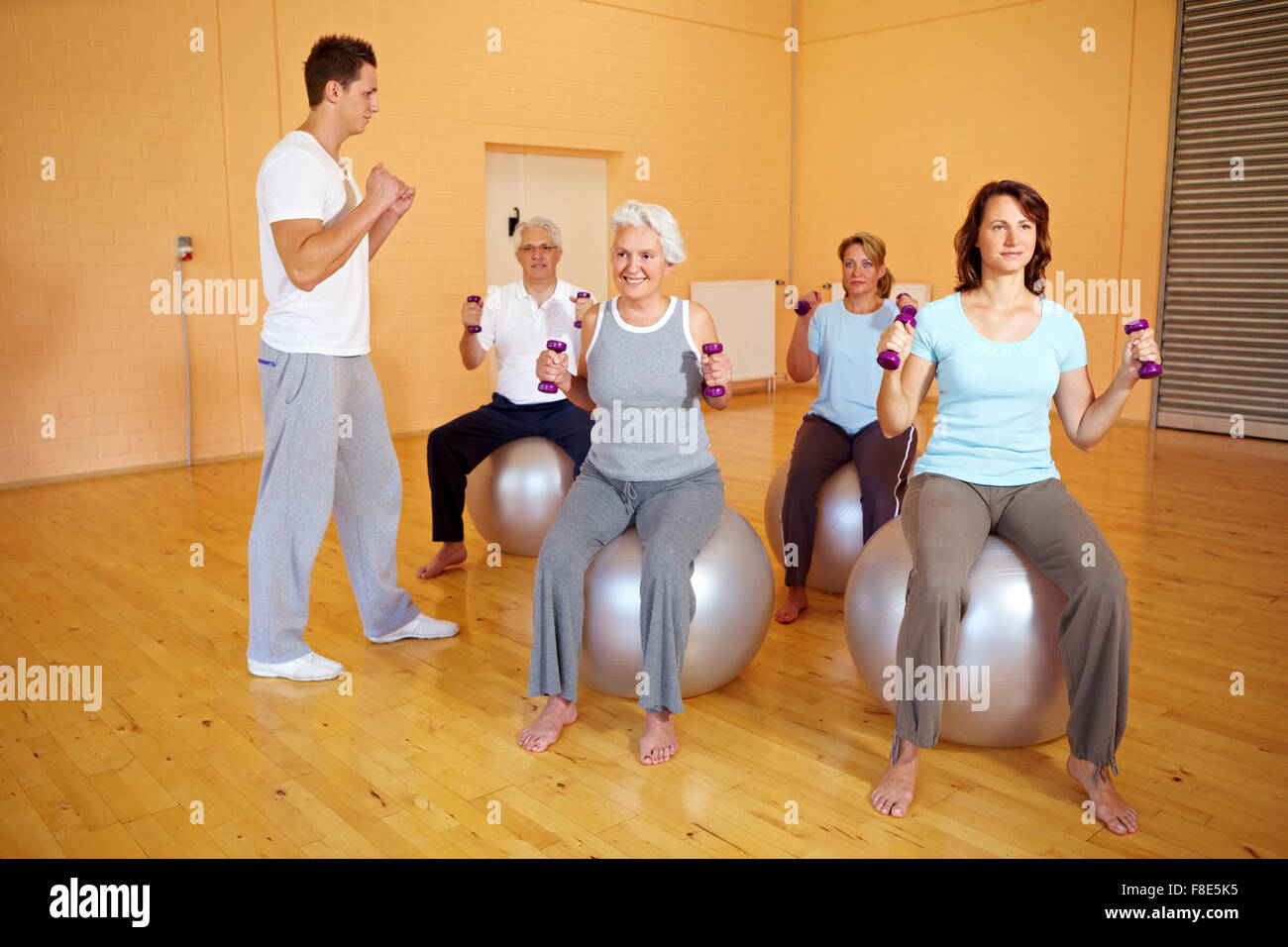 Fitness trainer explaining dumbbell exercises in a gym Stock Photo - Alamy