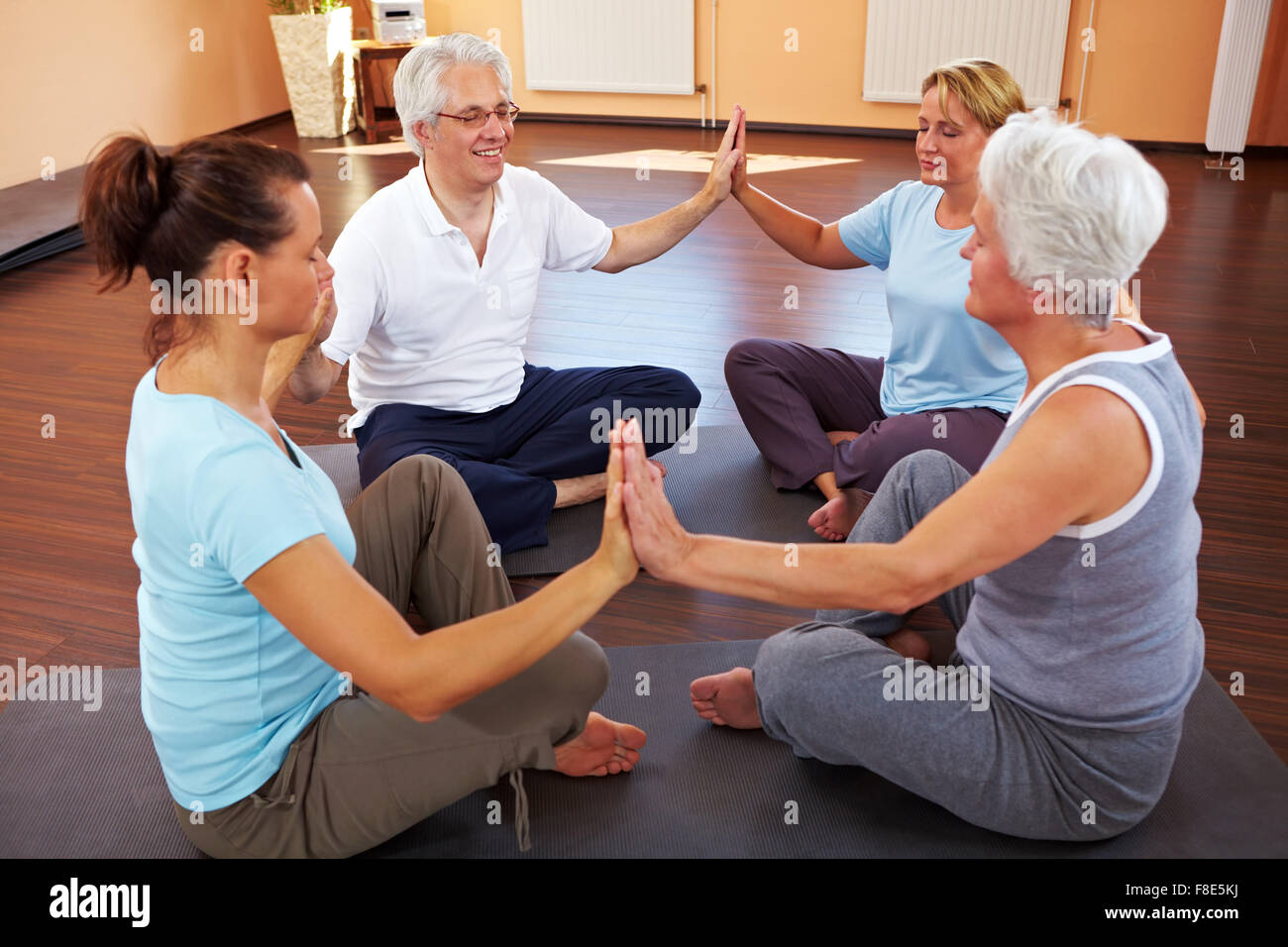 Happy group meditating in circle in a gym Stock Photo - Alamy