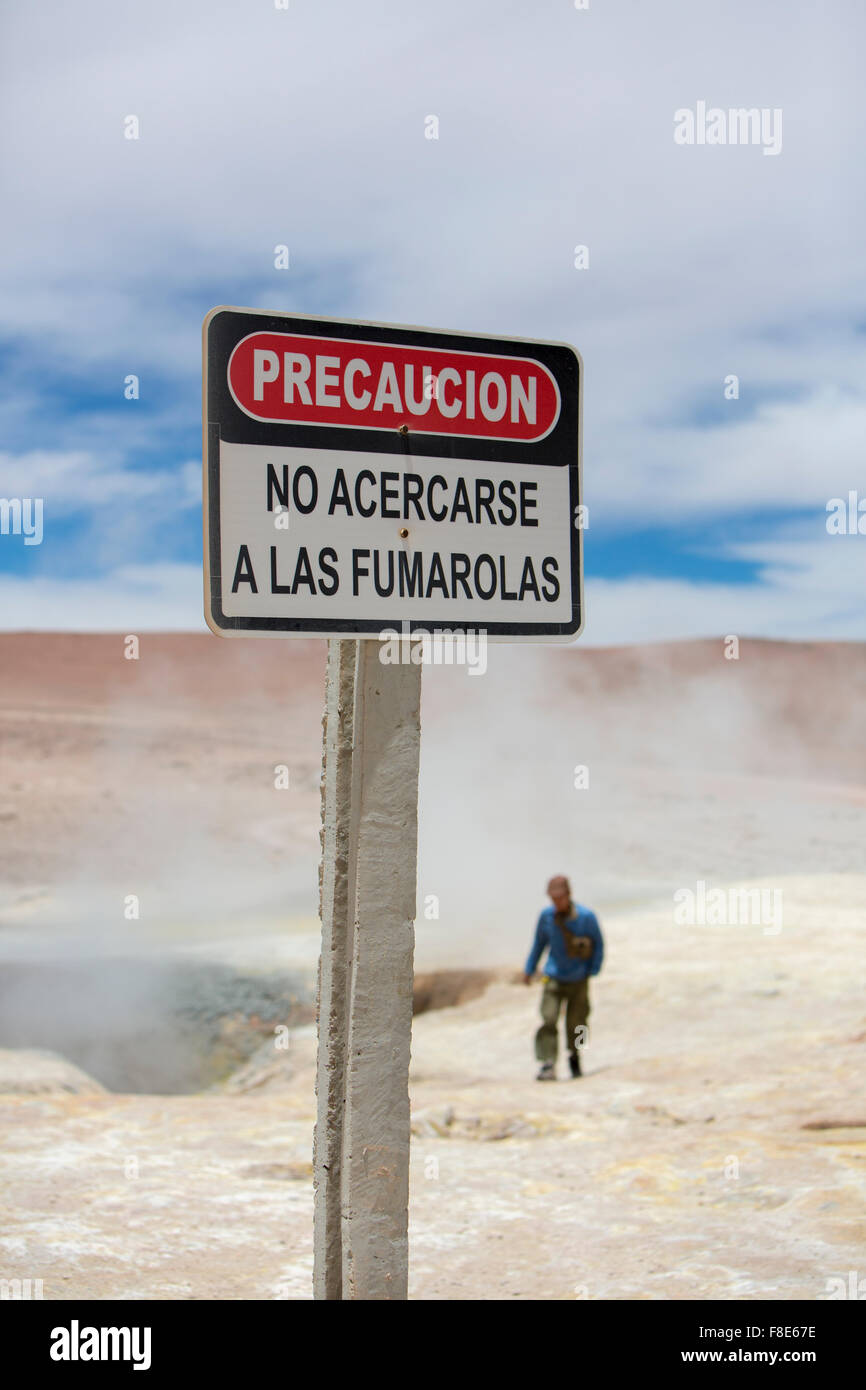 Silhouette of man walking behind a danger stop warning sign post in ...