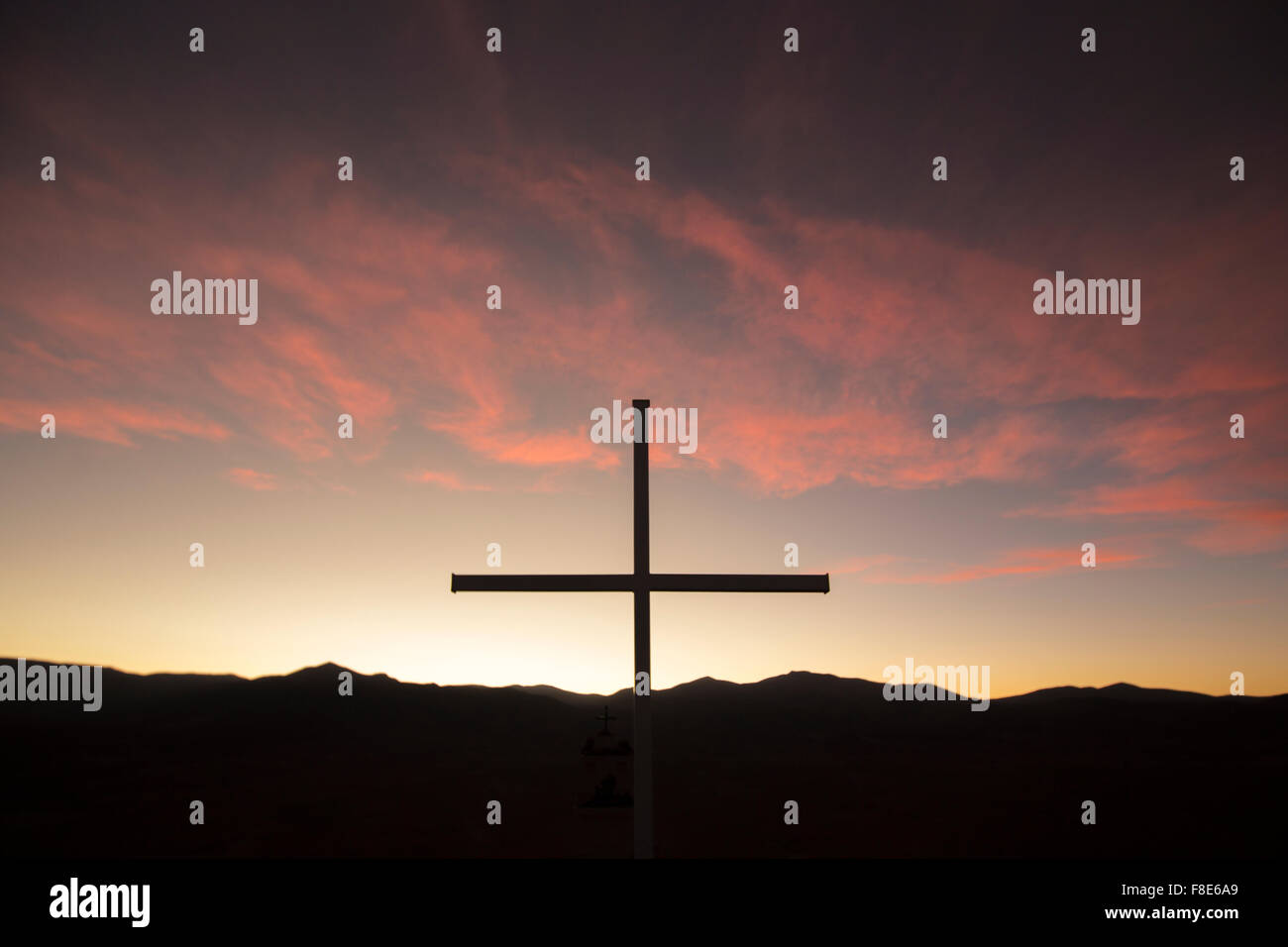 Colorful orange sunset with the silhouette of a Christian cross located ...