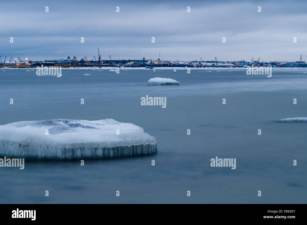 Ice floes of Baltic sea, cargo port on background Stock Photo - Alamy