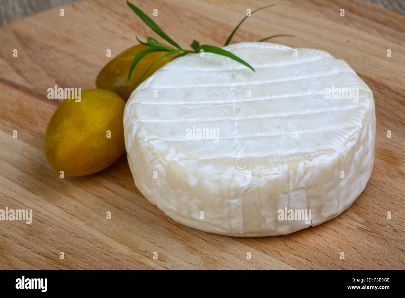 Round Brie cheese with yellow plums and estragon Stock Photo - Alamy