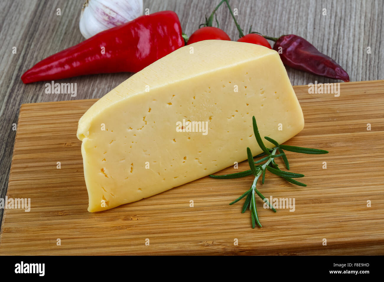 Yellow cheese triangle with rosemary herbs on the wood background Stock ...