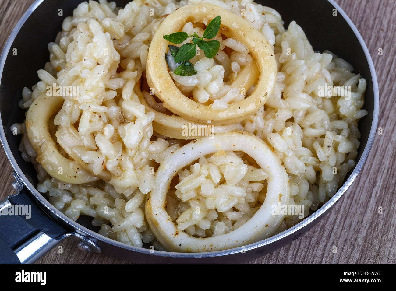 Italian famous cuisine - Squid risotto served basil leaves Stock Photo ...