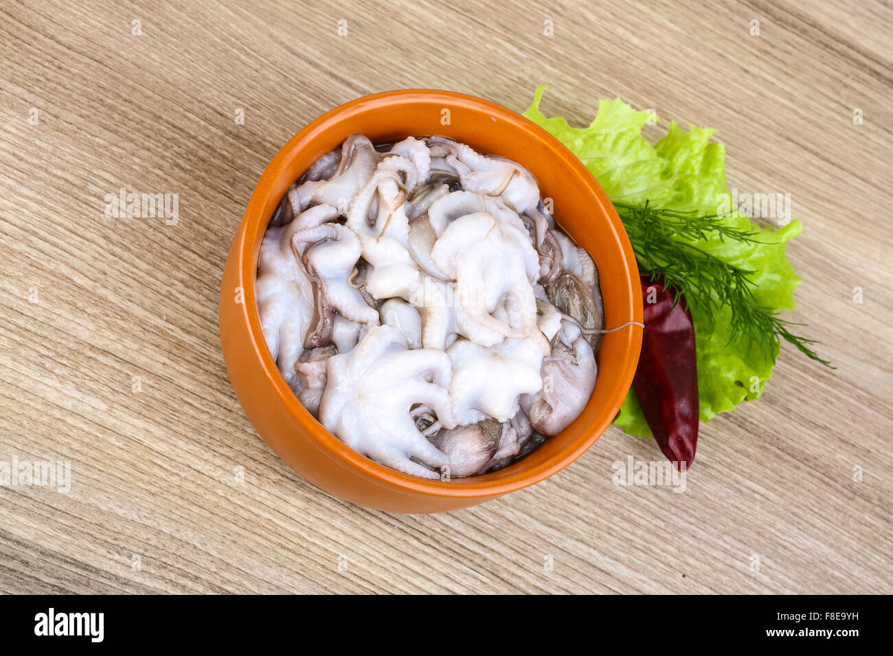 Raw baby octopus in the bowl ready for cooking Stock Photo - Alamy