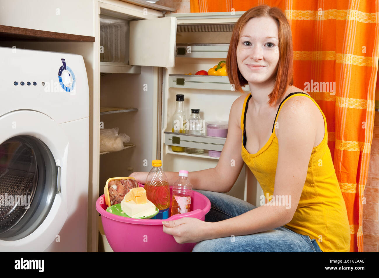 Young woman defrosting the refrigerator at her kitchen Stock Photo - Alamy