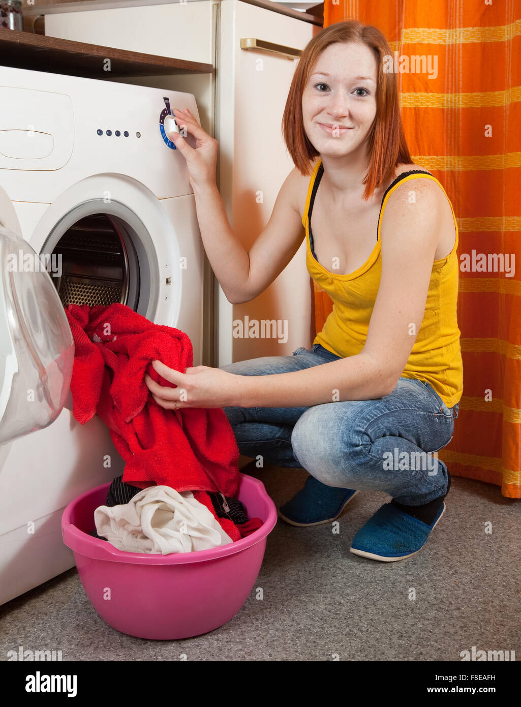 Young woman doing laundry at her home Stock Photo - Alamy