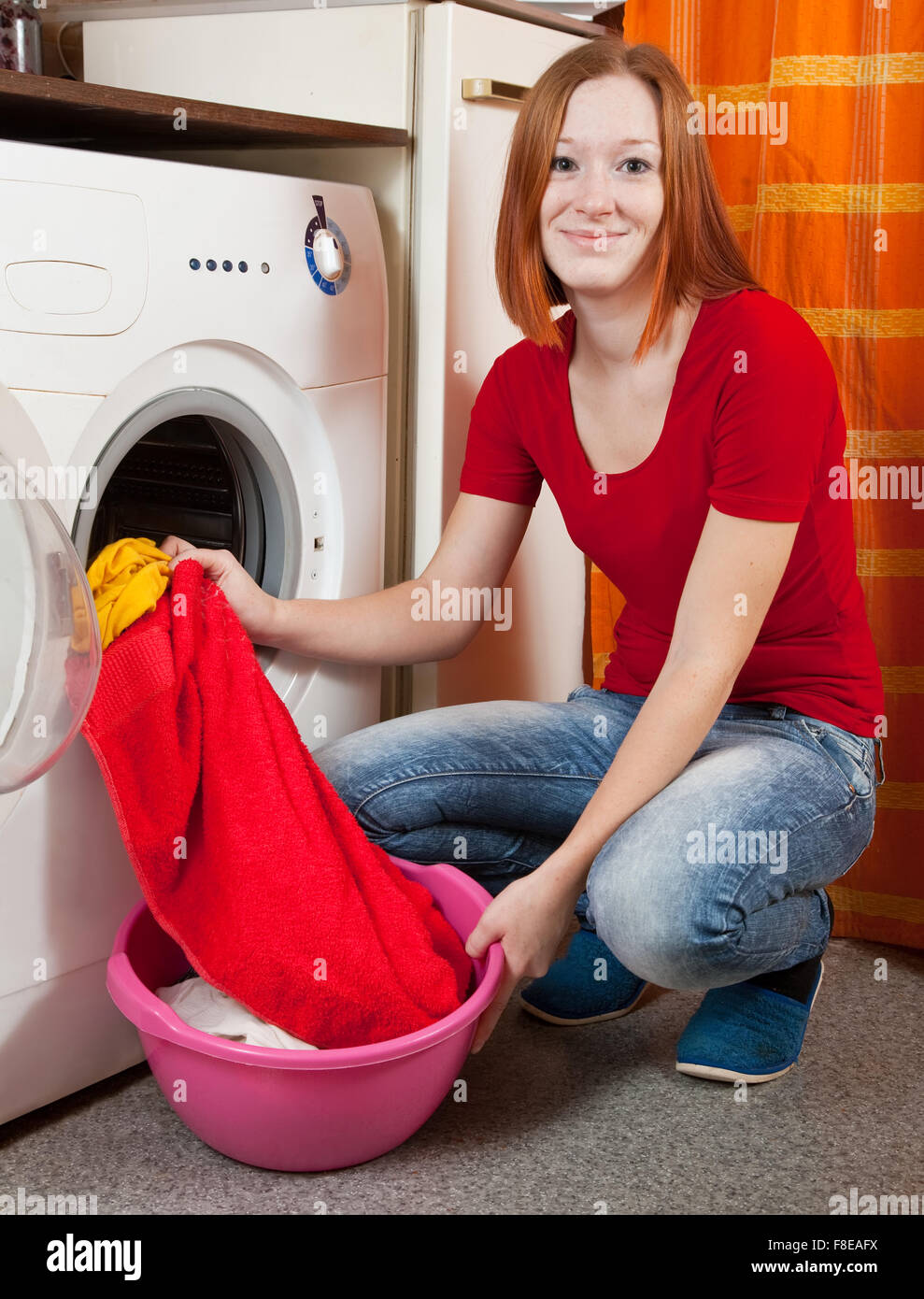 Young woman doing laundry at her home Stock Photo - Alamy