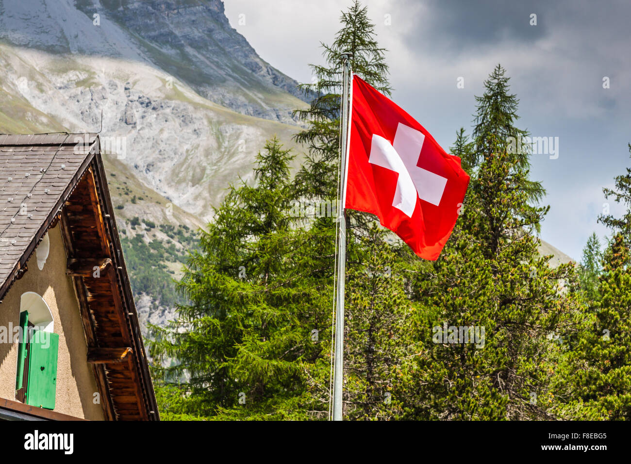 Swiss flag - national symbol of Switzerland with Alps in background ...