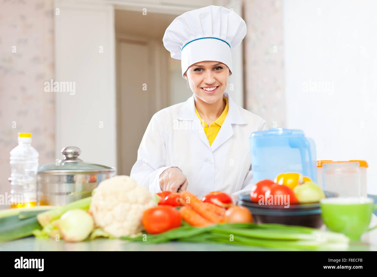 cook woman in uniform cutting vegetables at commercial kitchen Stock ...