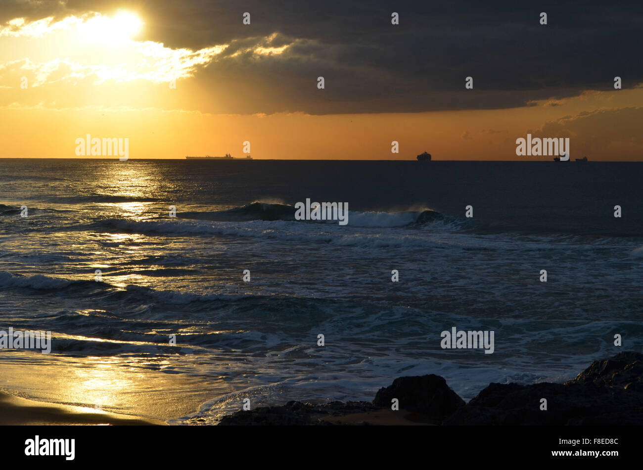 Golden sunrise over sea with ships on horizon Stock Photo - Alamy