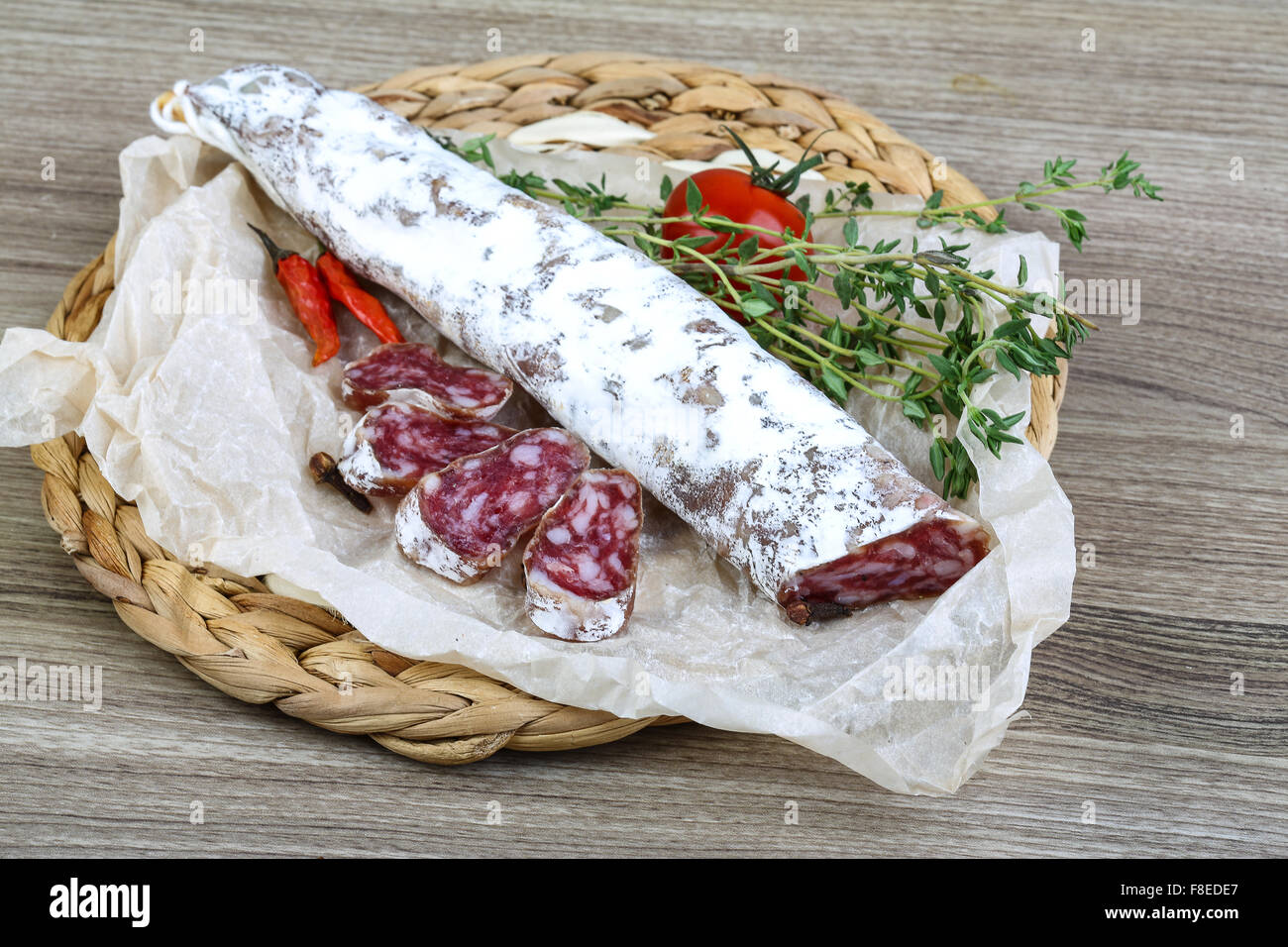 Traditional Spanish sausages- fuet with thyme leaves on the wood ...