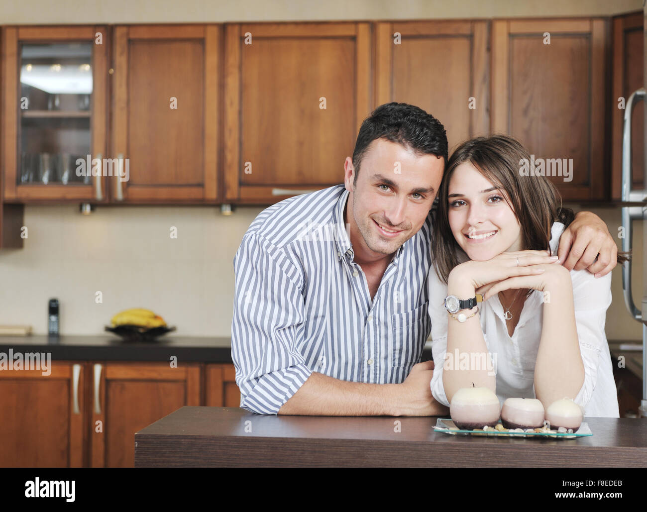 happy young couple have fun in modern wooden kitchen indoor while ...