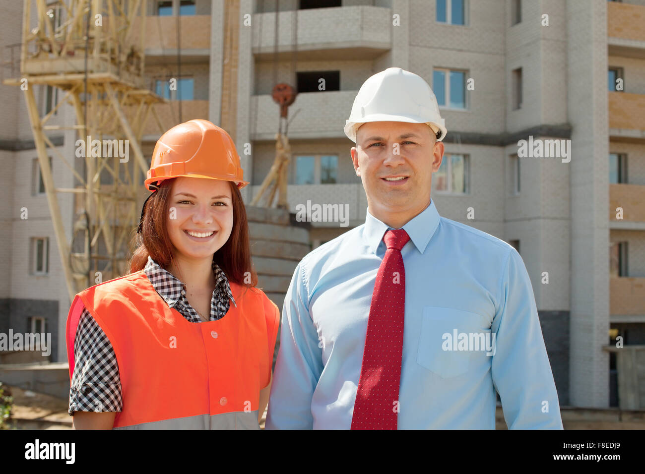 Portrait of two builders standing at building site Stock Photo - Alamy