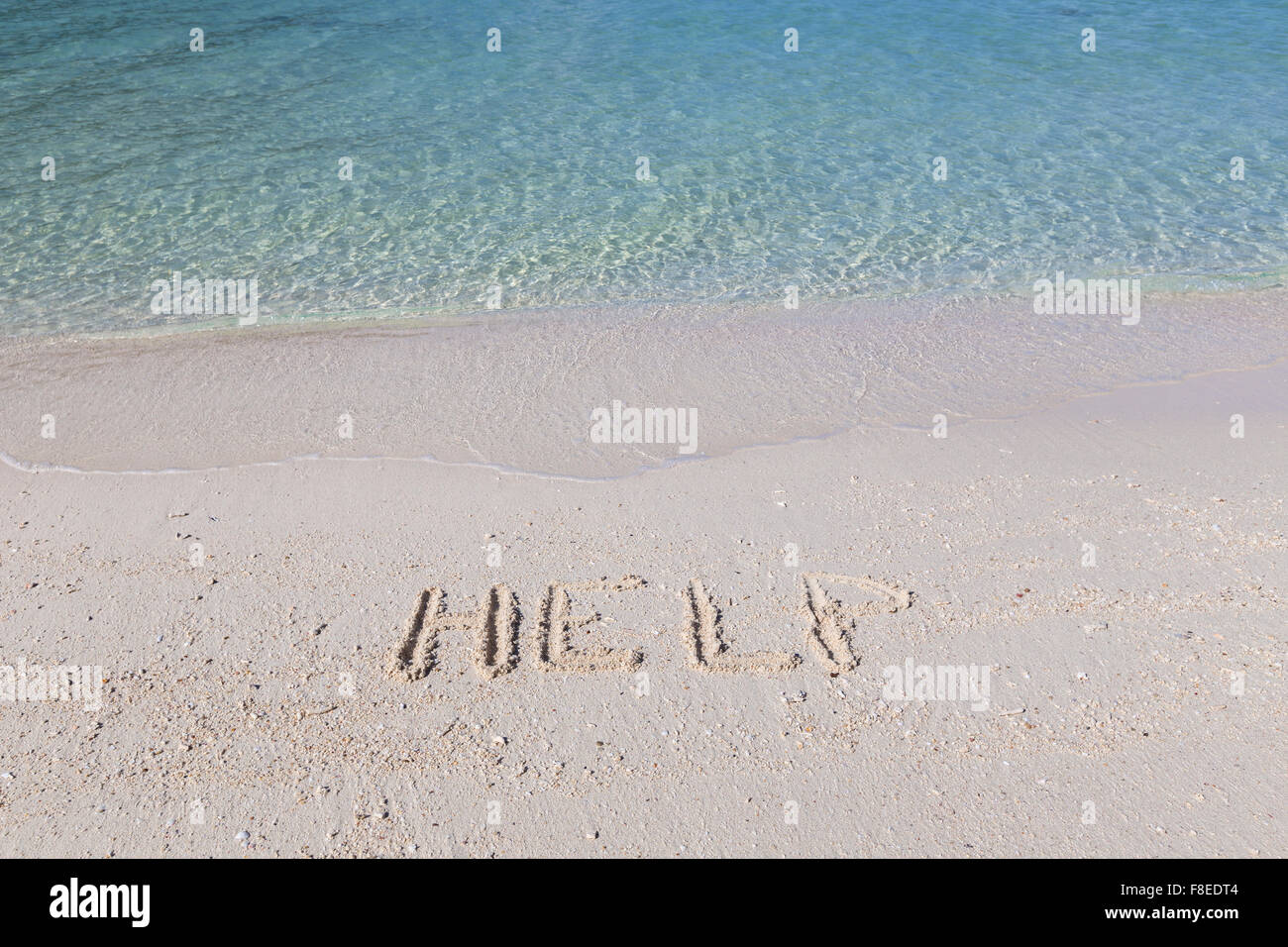 Help written out in wet sand on a tropical beach Stock Photo - Alamy