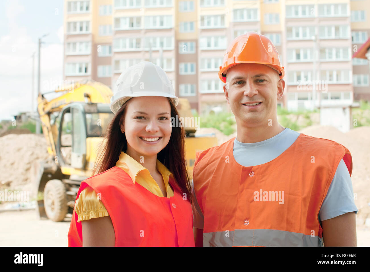 Portrait of two builders standing at building site Stock Photo - Alamy