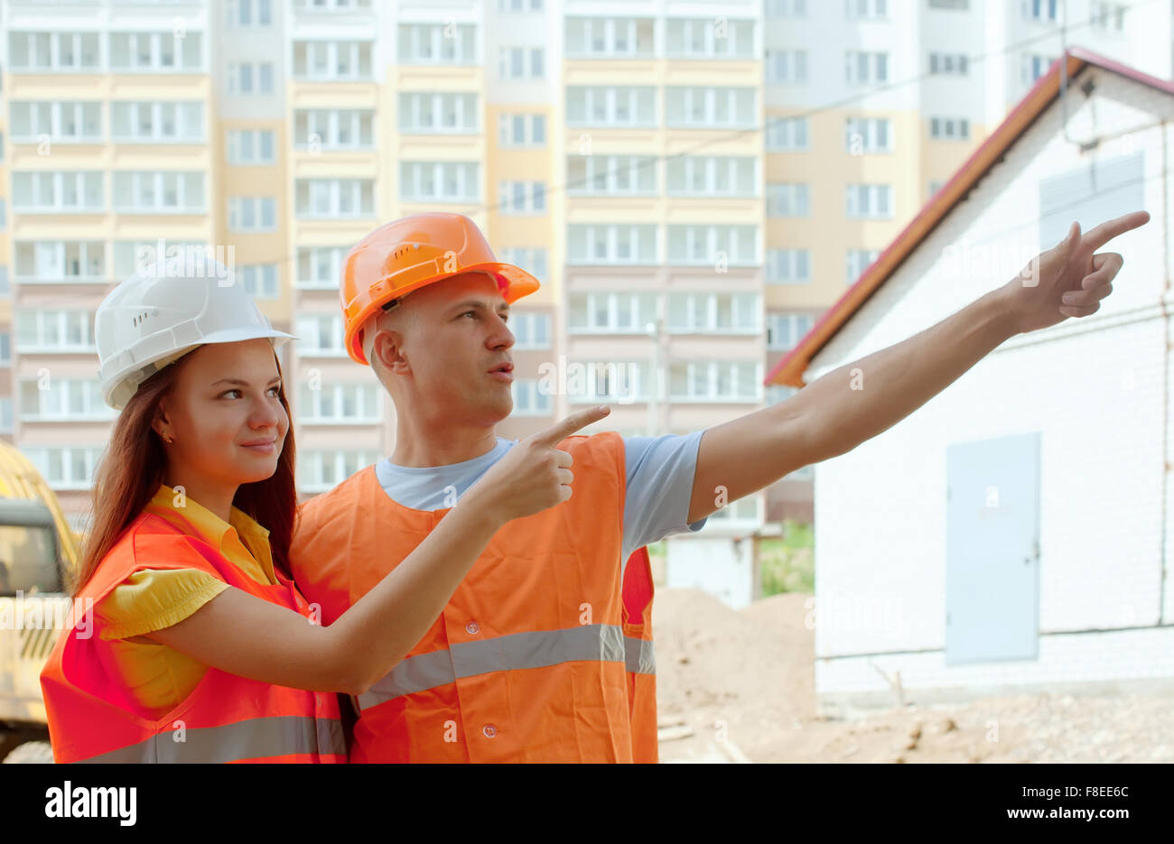 Portrait of two builders standing at building site Stock Photo - Alamy