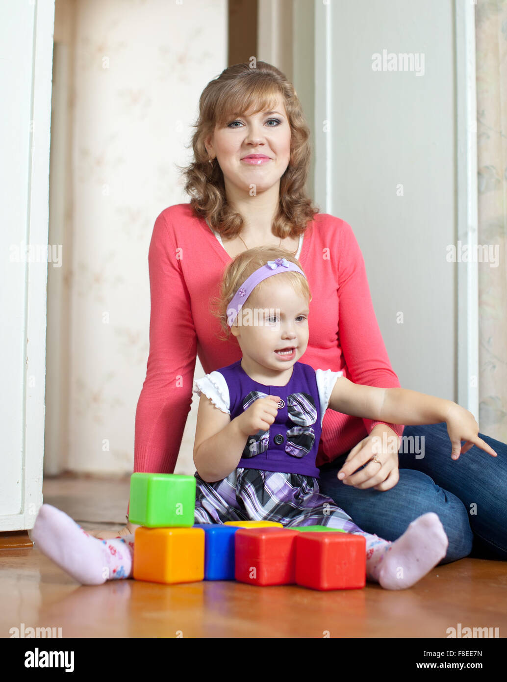 Happy mother plays with baby in home interior Stock Photo - Alamy