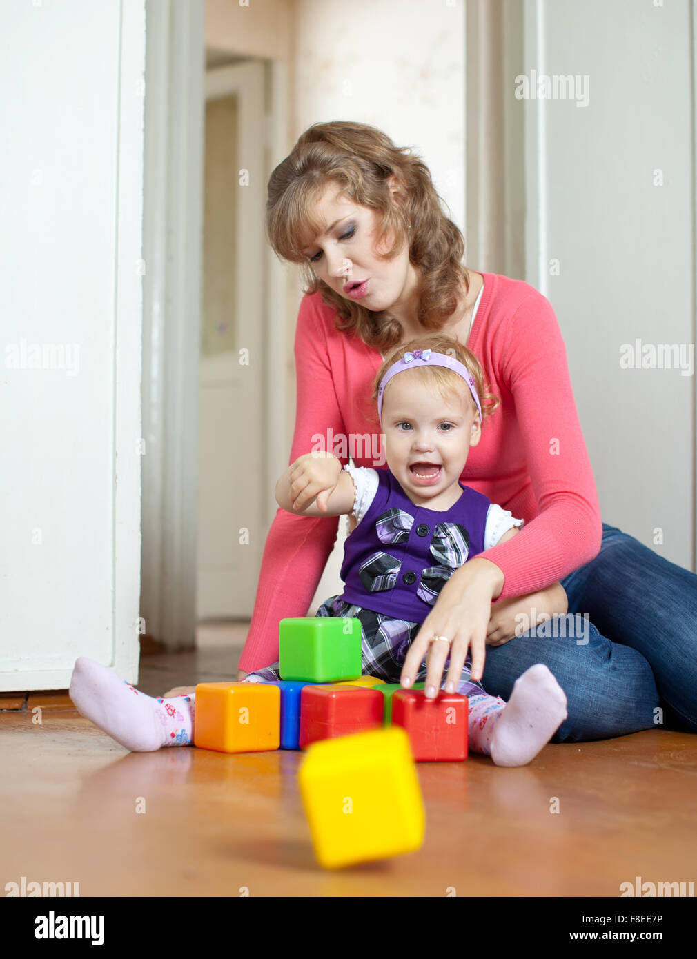 Happy mother plays with baby in home interior Stock Photo - Alamy