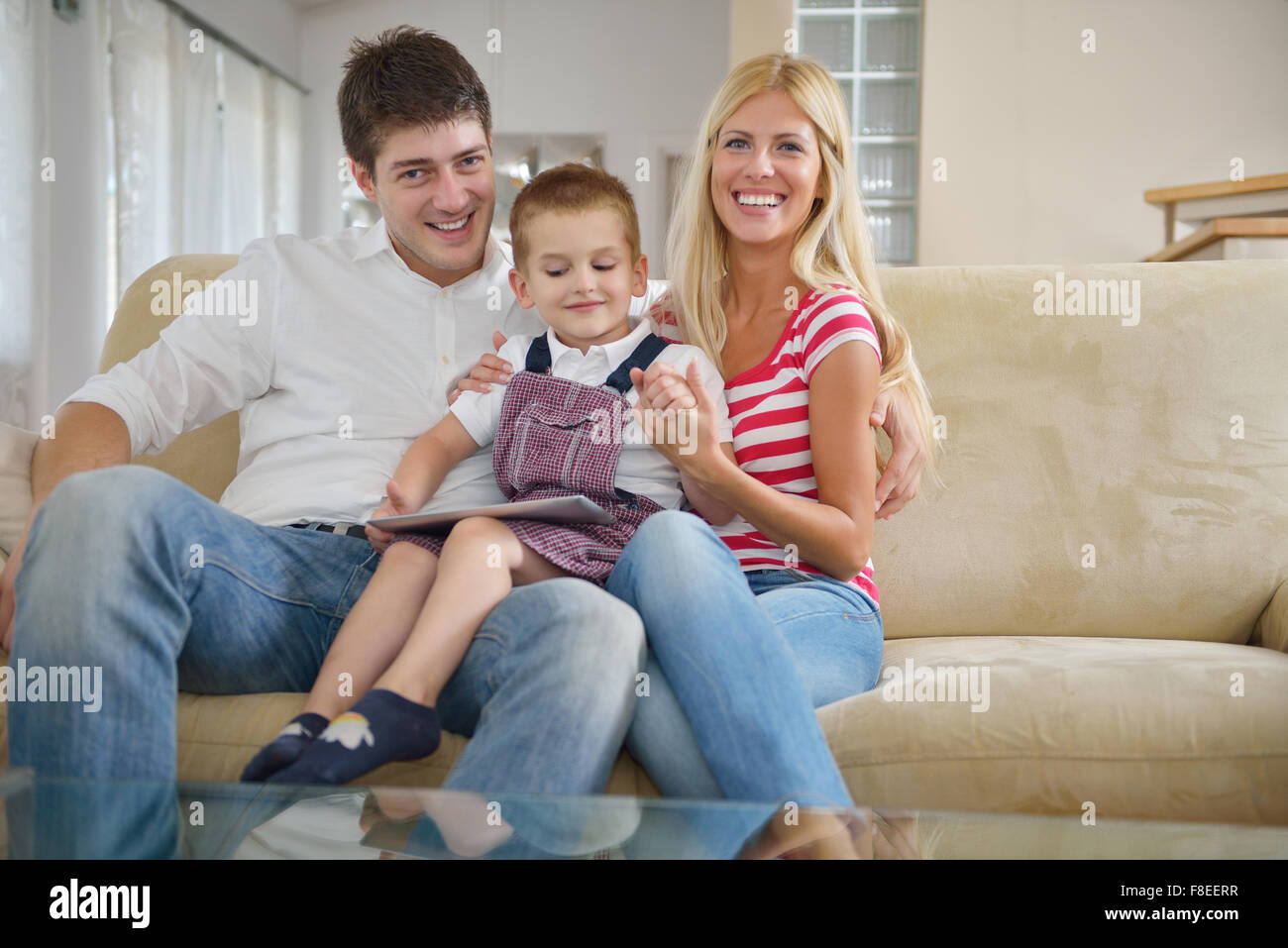 happy young family using tablet computer at modern home for playing ...