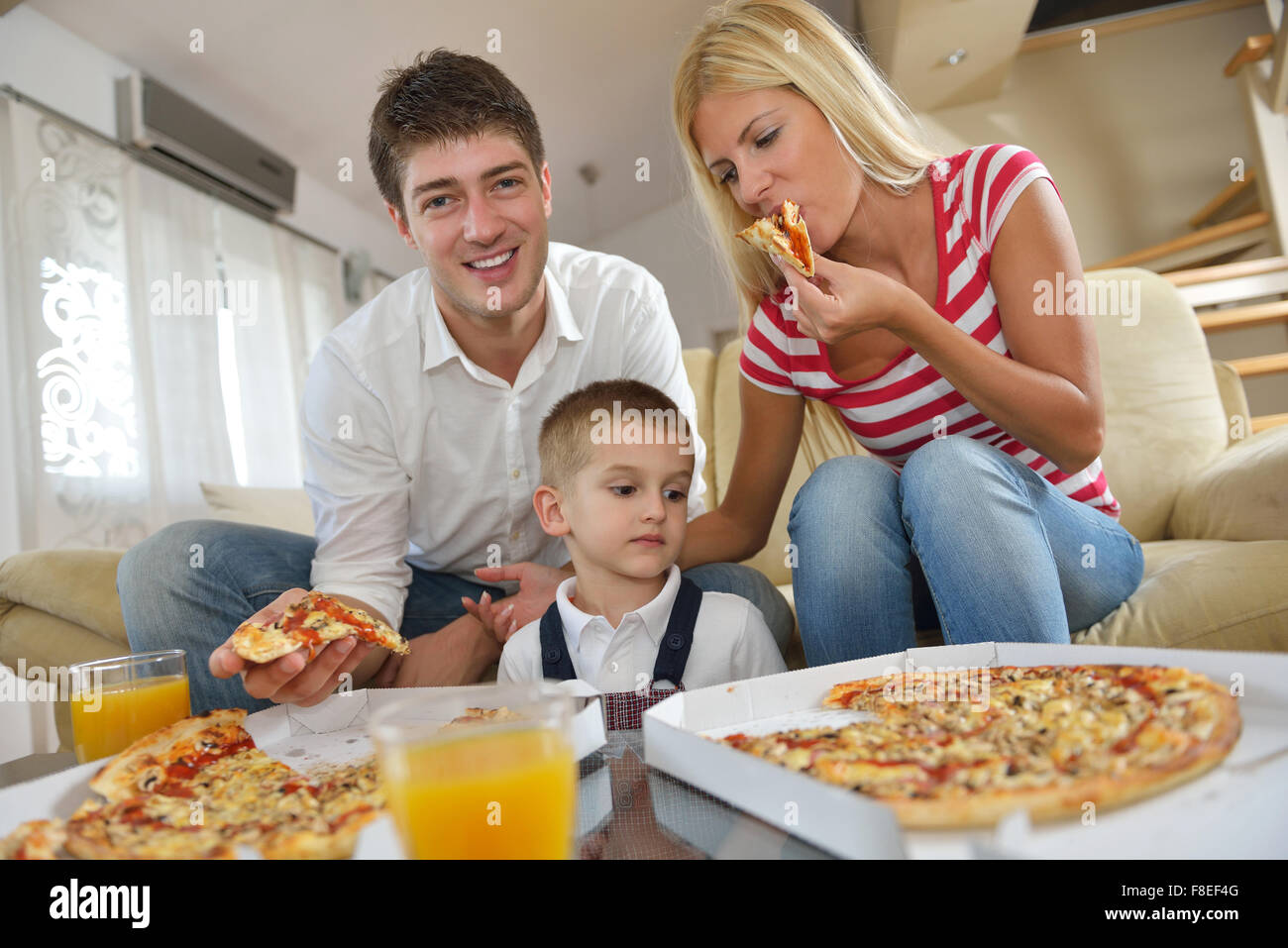 happy young family eating tasty pizza with cheesa and dring healthy and ...