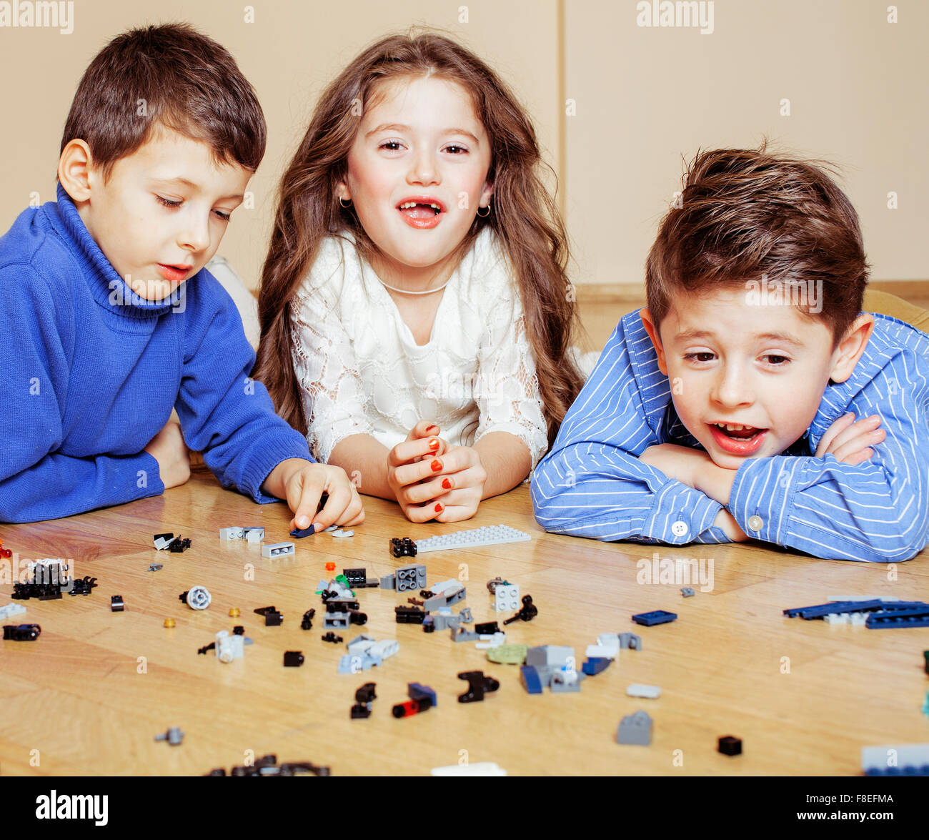funny cute children playing lego at home, boys and girl smiling, first ...