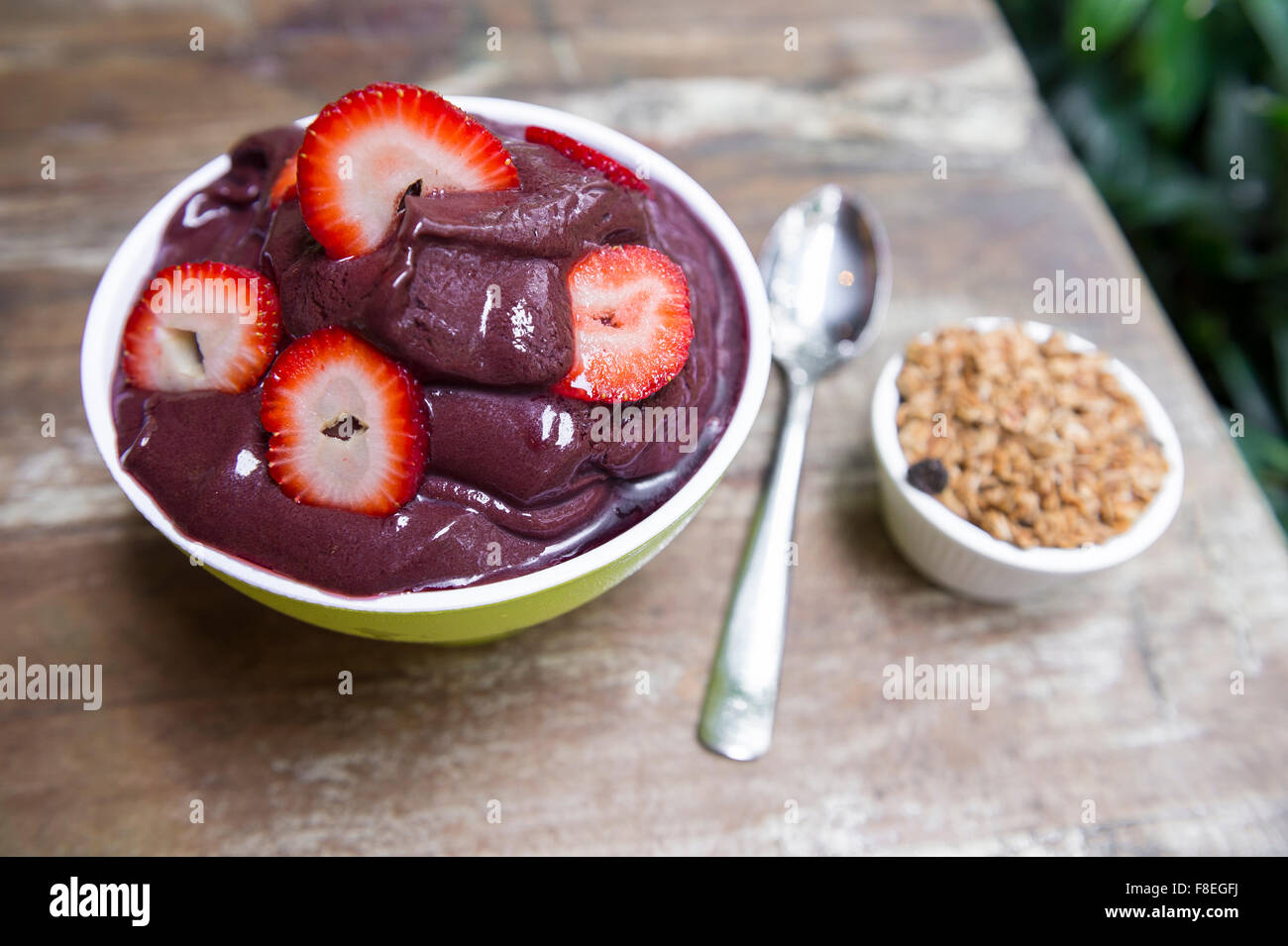 Bowl of fresh Brazilian acai garnished with strawberries and granola on ...