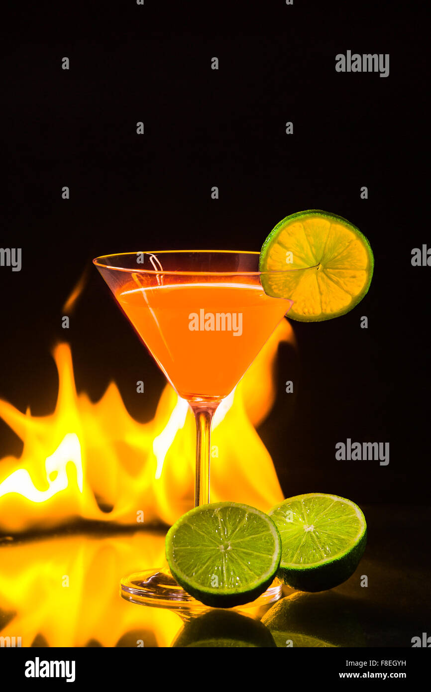 colorful orange cocktail in nice carroty color to front of a black ...
