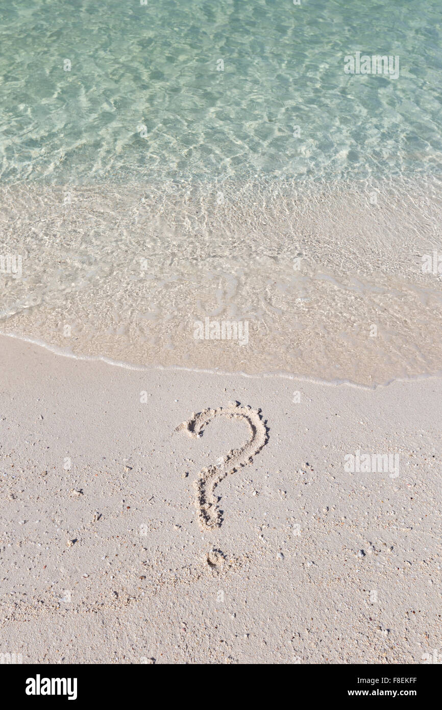 Question mark written out in wet sand on a tropical beach in Thailand ...