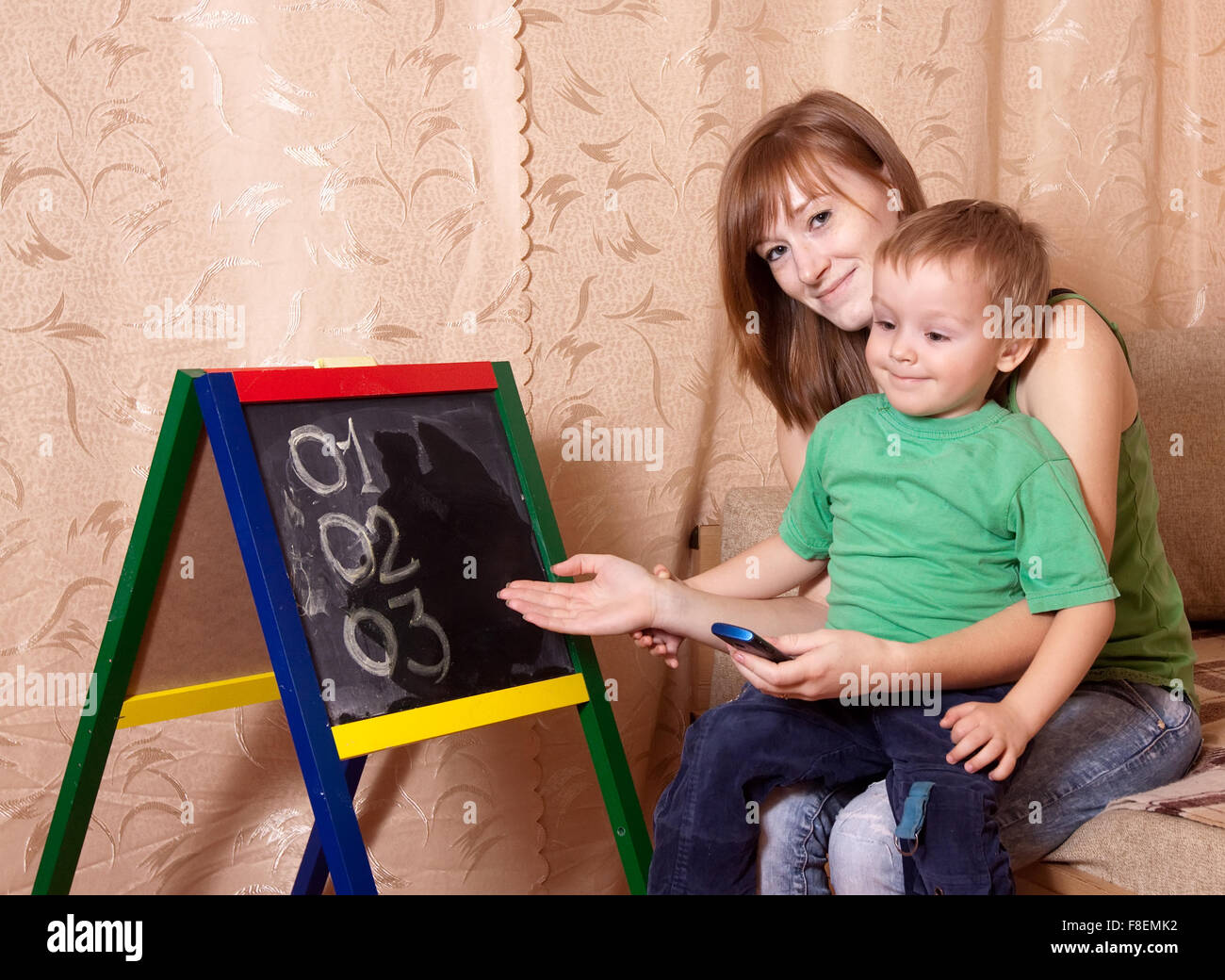 Mother teaches child to emergency phone numbers Stock Photo - Alamy
