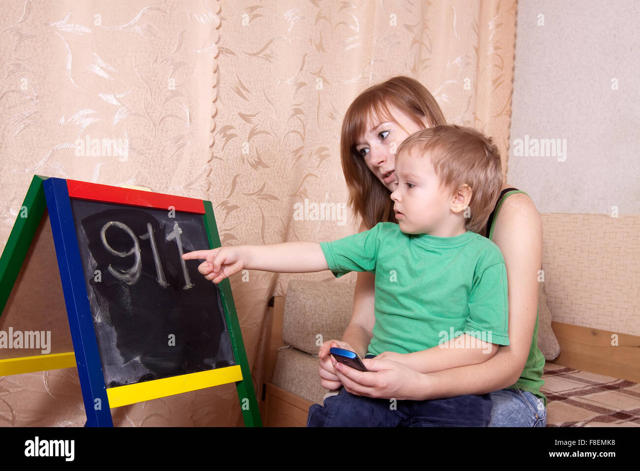 Mother teaches child to emergency phone numbers Stock Photo - Alamy