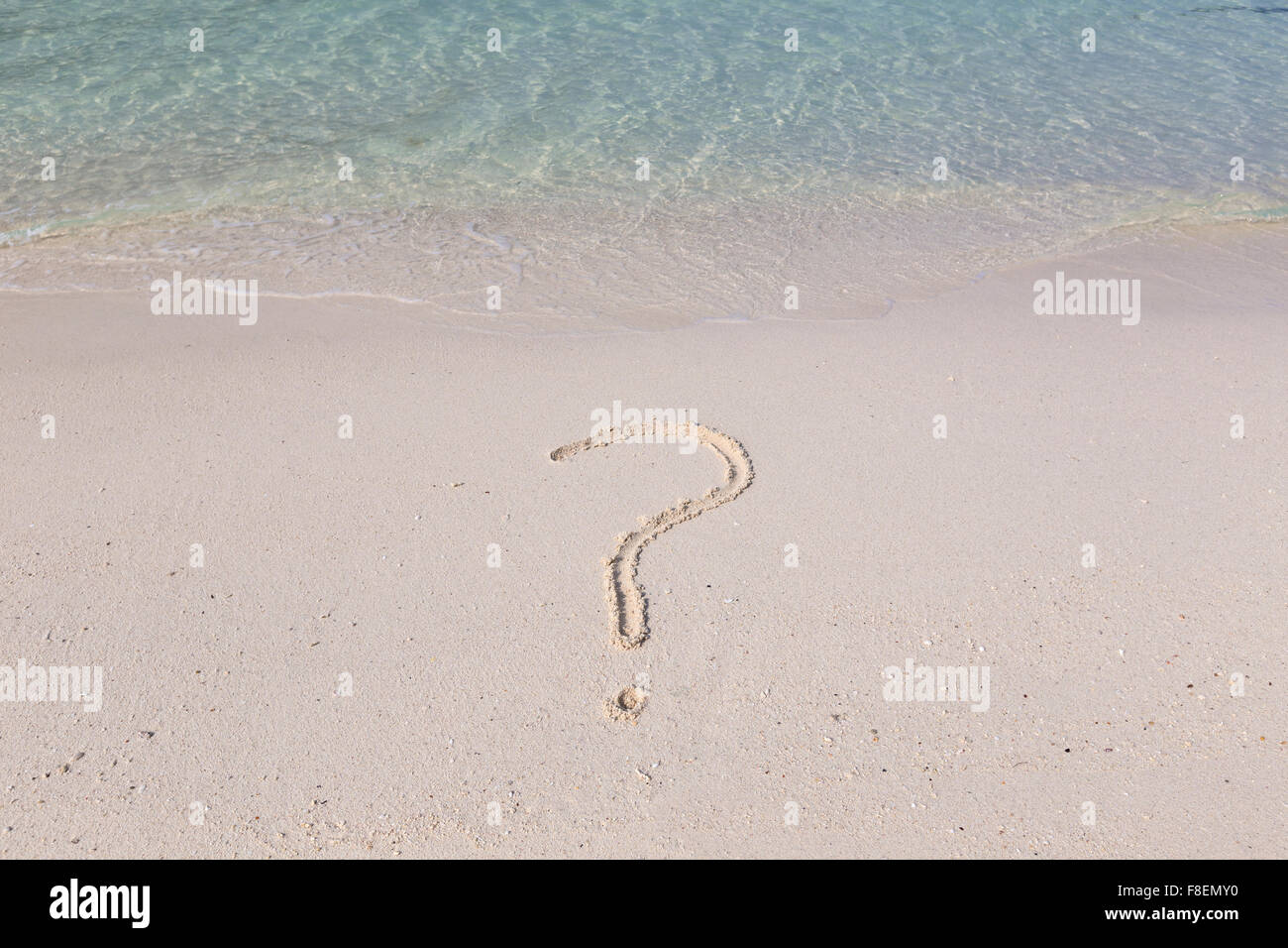 Question mark written out in wet sand on a tropical beach in Thailand ...