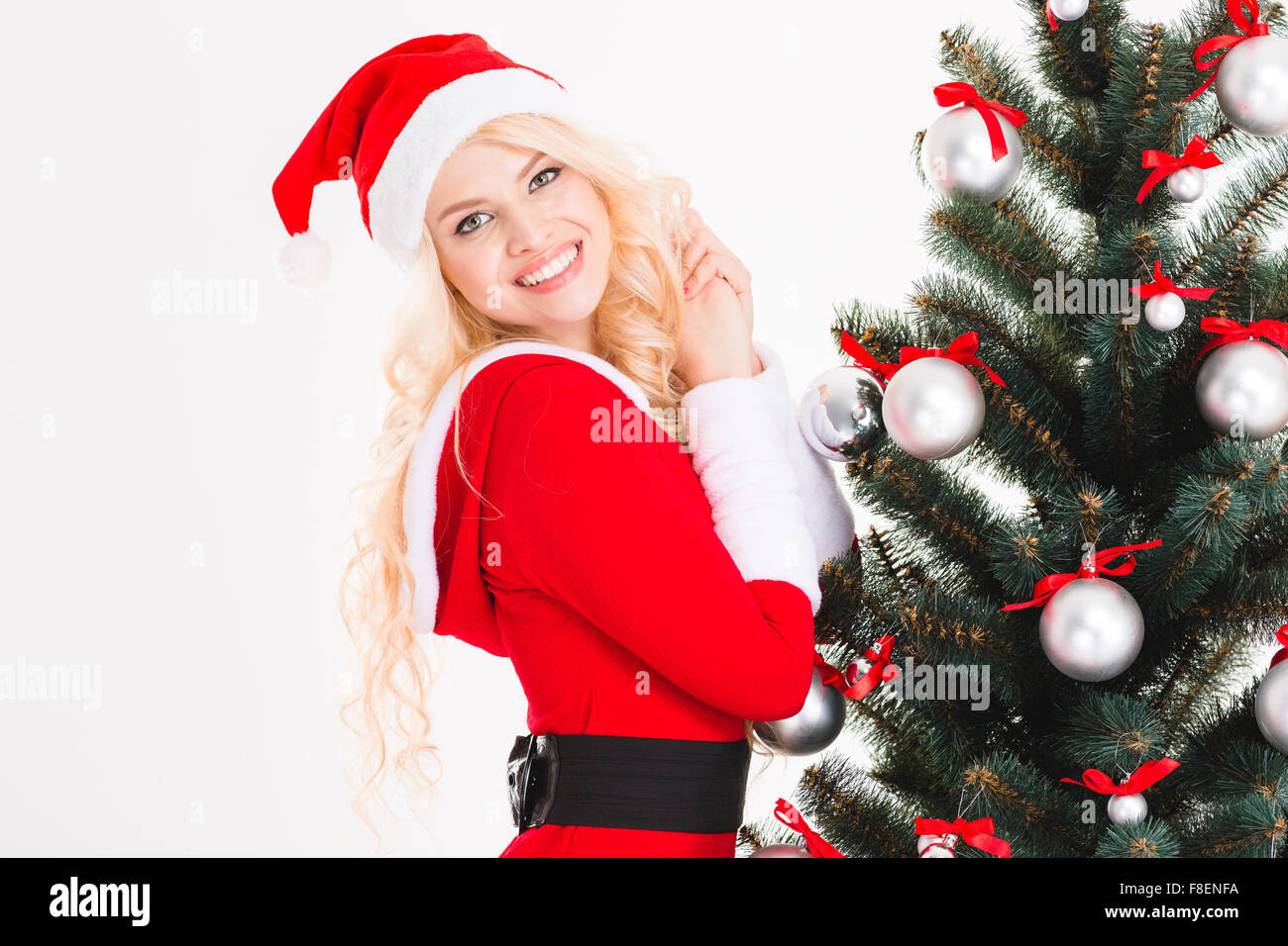 Portrait of beautiful cheerful young woman in red santa claus costume ...