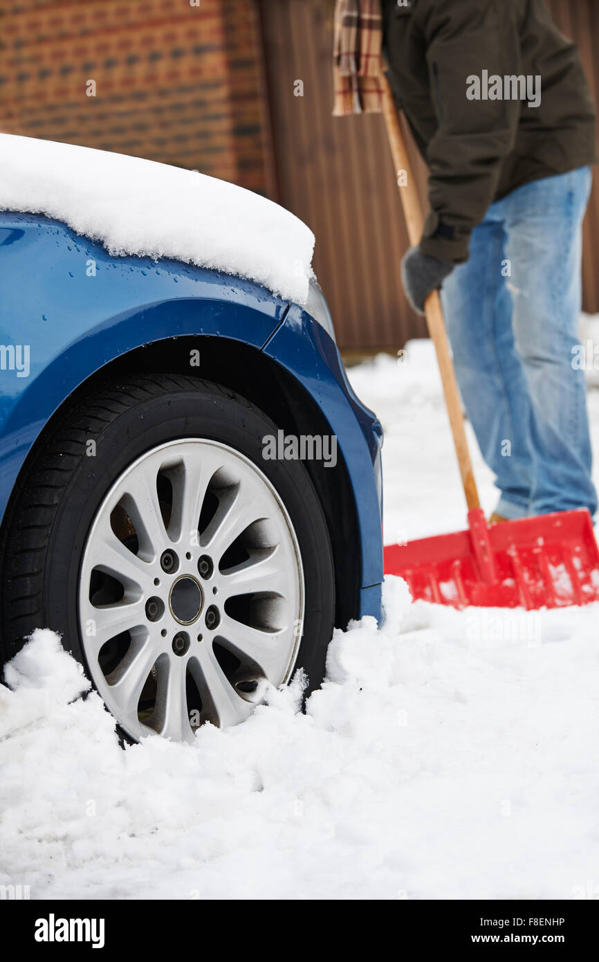 Motorist Digging Car Out Of Snow Stock Photo - Alamy