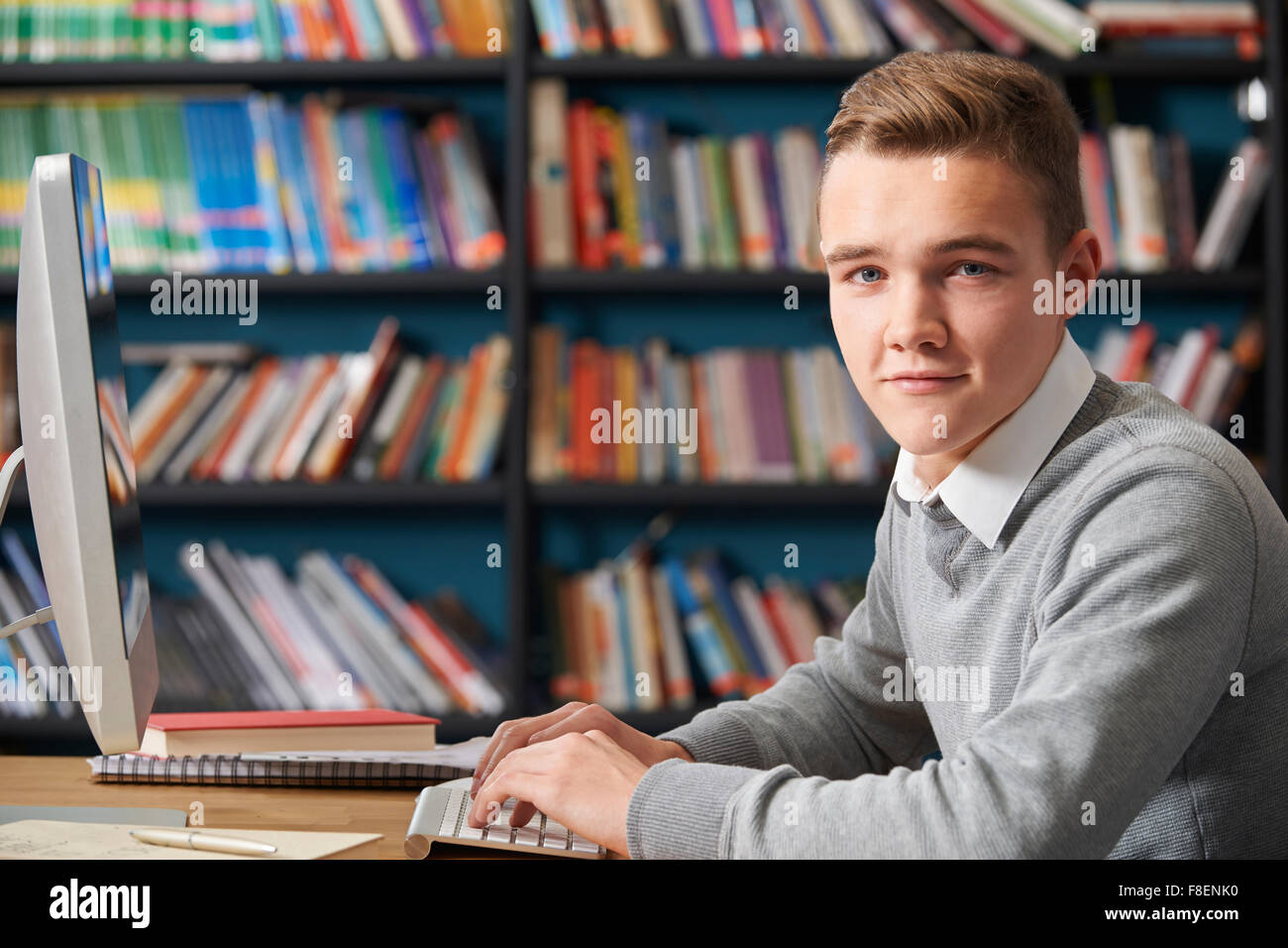 Male Teenage Student Working At Computer In Library Stock Photo - Alamy