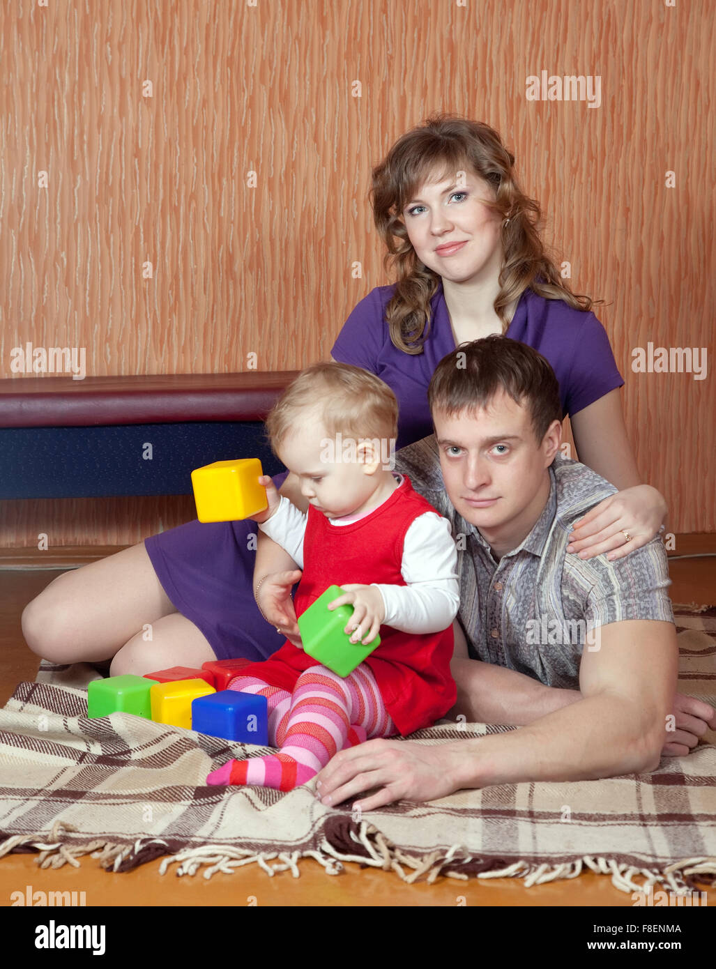 parents and child relaxing at home on floor Stock Photo - Alamy