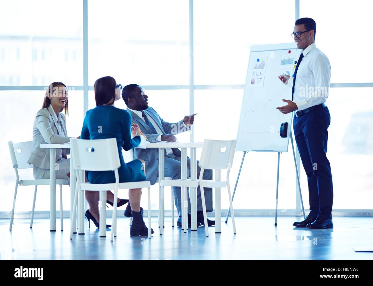 Cheerful business people looking at successful specialist explaining ...
