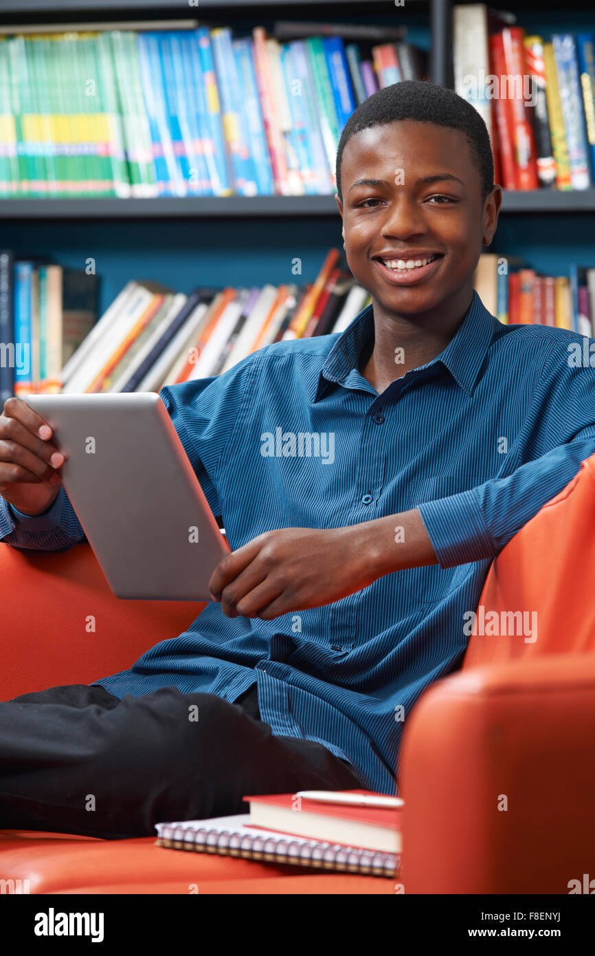 Male Teenage Student Using Digital Tablet In Library Stock Photo - Alamy