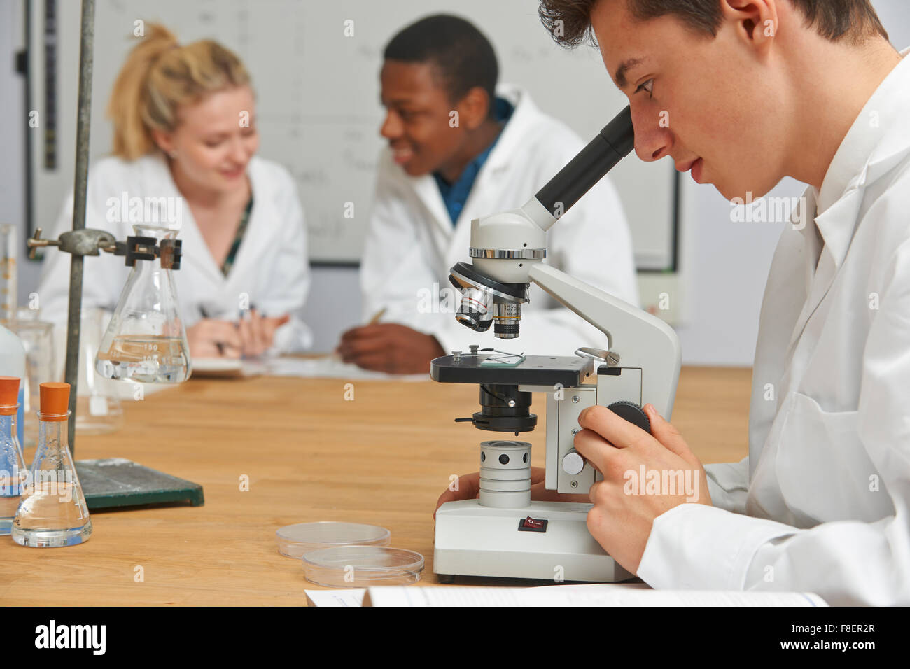 Teenage Students In Science Class Using Microscope Stock Photo - Alamy